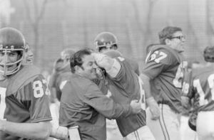 Coach Alex Agase on the sideline with players